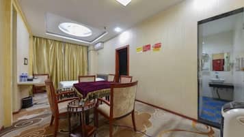 Quarto de hotel com área de refeições, cama, banheiro e vista para o exterior.