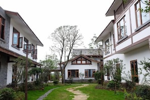 Pátio com caminho central, cercado por edifícios com arquitetura tradicional.