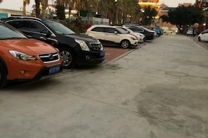 Um estacionamento com vários carros estacionados em fila.
