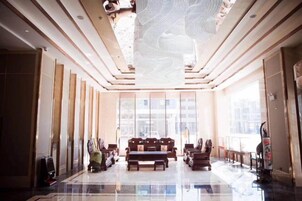 Um hall espaçoso com teto alto, grandes janelas e um espaço de estar central.