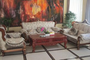 Quarto com sofá, mesa de centro e uma grande pintura abstrata na parede.