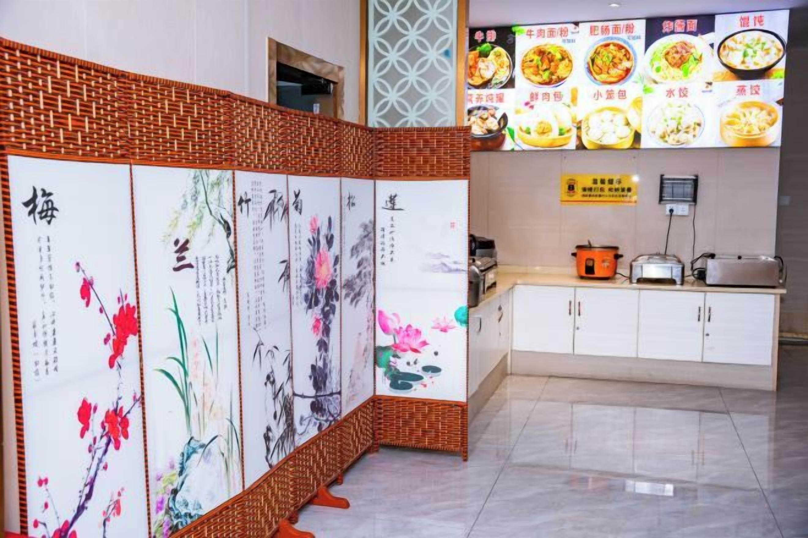 Quarto com um ecrã tradicional chinês, área de cozinha com fogão e torradeira, e uma parede exibindo alimentos.