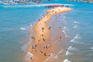 Uma praia com pessoas e um barco.