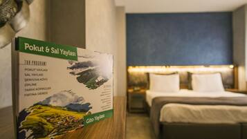 Quarto de hotel com cama, mesa de cabeceira e um aviso sobre Pokut & Sal Yaylası.