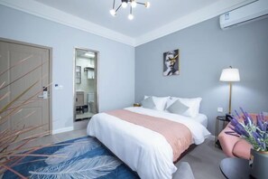 Quarto moderno com cama, mesa de cabeceira e abajur.