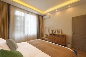 Um quarto com uma cama, uma cômoda e uma porta.