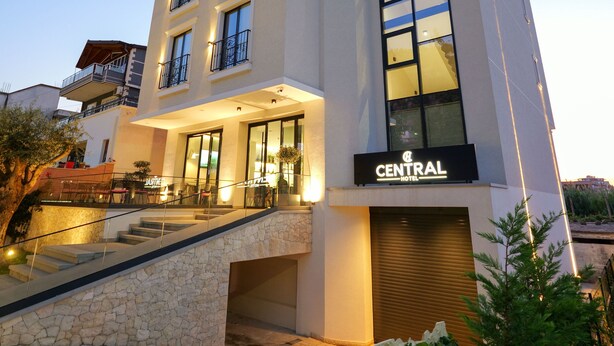 Um hotel moderno com entrada imponente, vários andares e fachada bem iluminada.