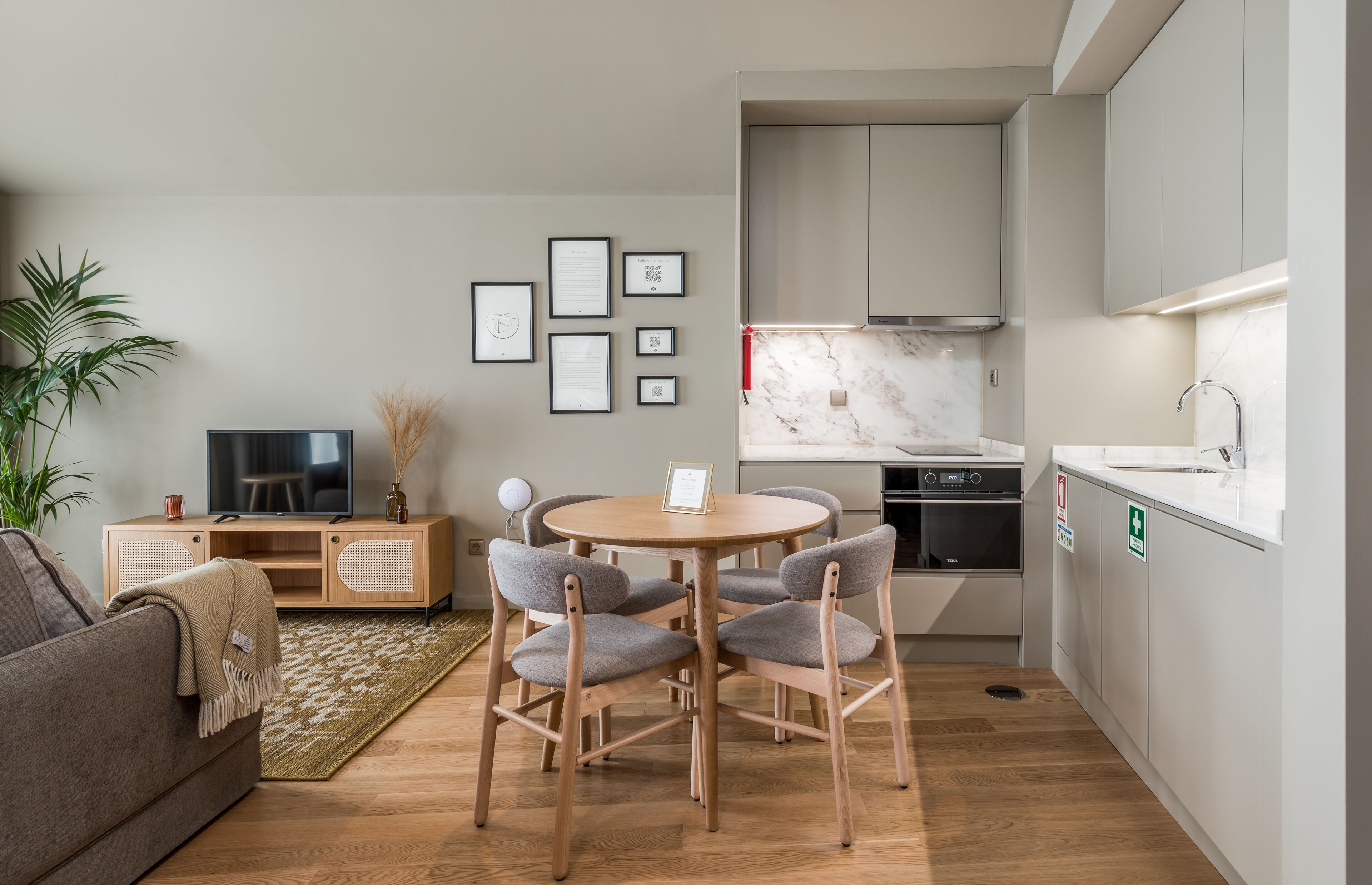 Um espaço compacto com área de refeições, cozinha compacta e sofá.