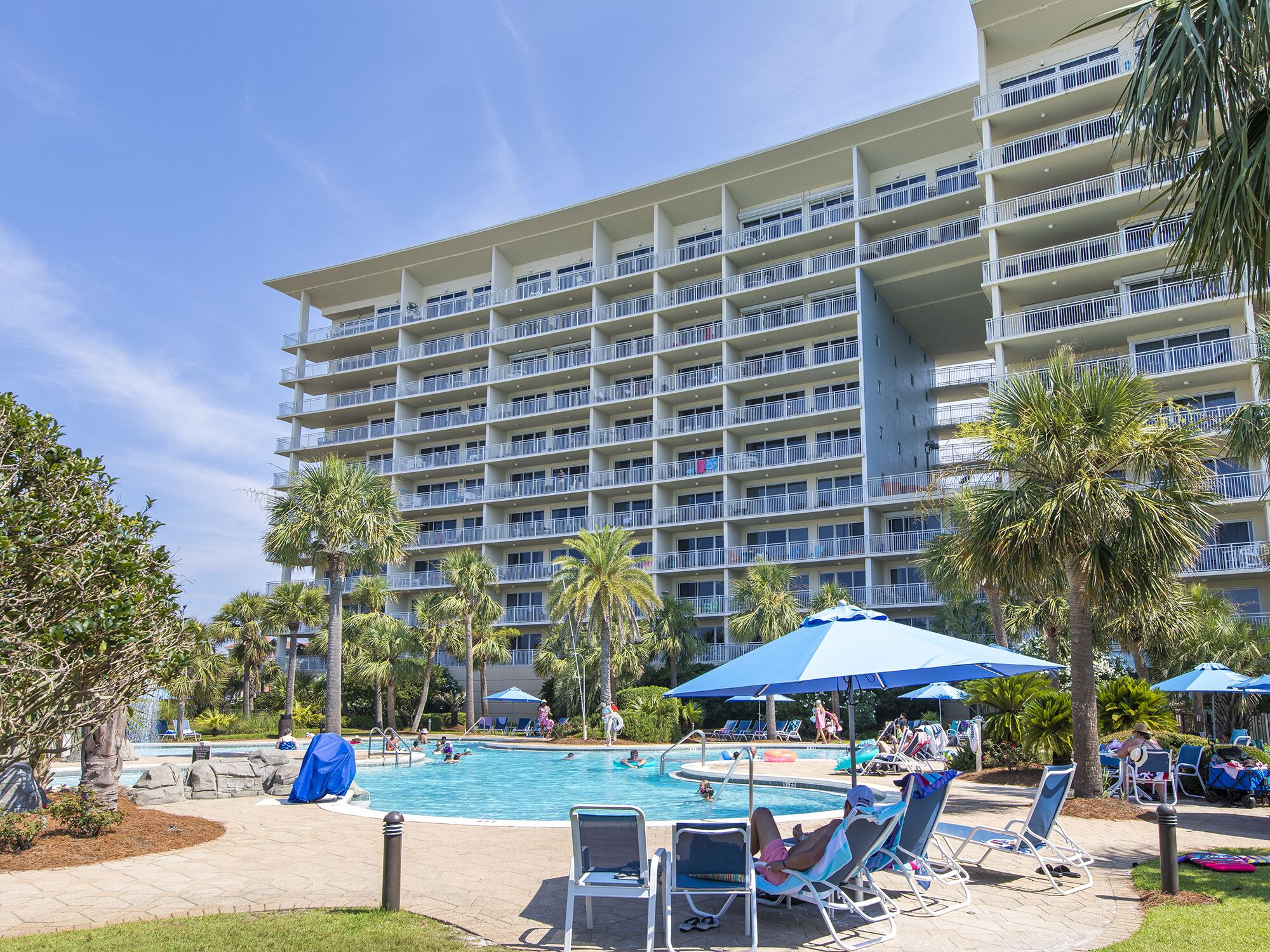 Um hotel com várias varandas, uma piscina e áreas de estar ao ar livre.