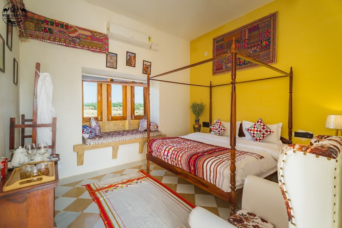 Uma cama com dossel sobre um piso xadrez, um banco com almofadas e uma janela com vista.