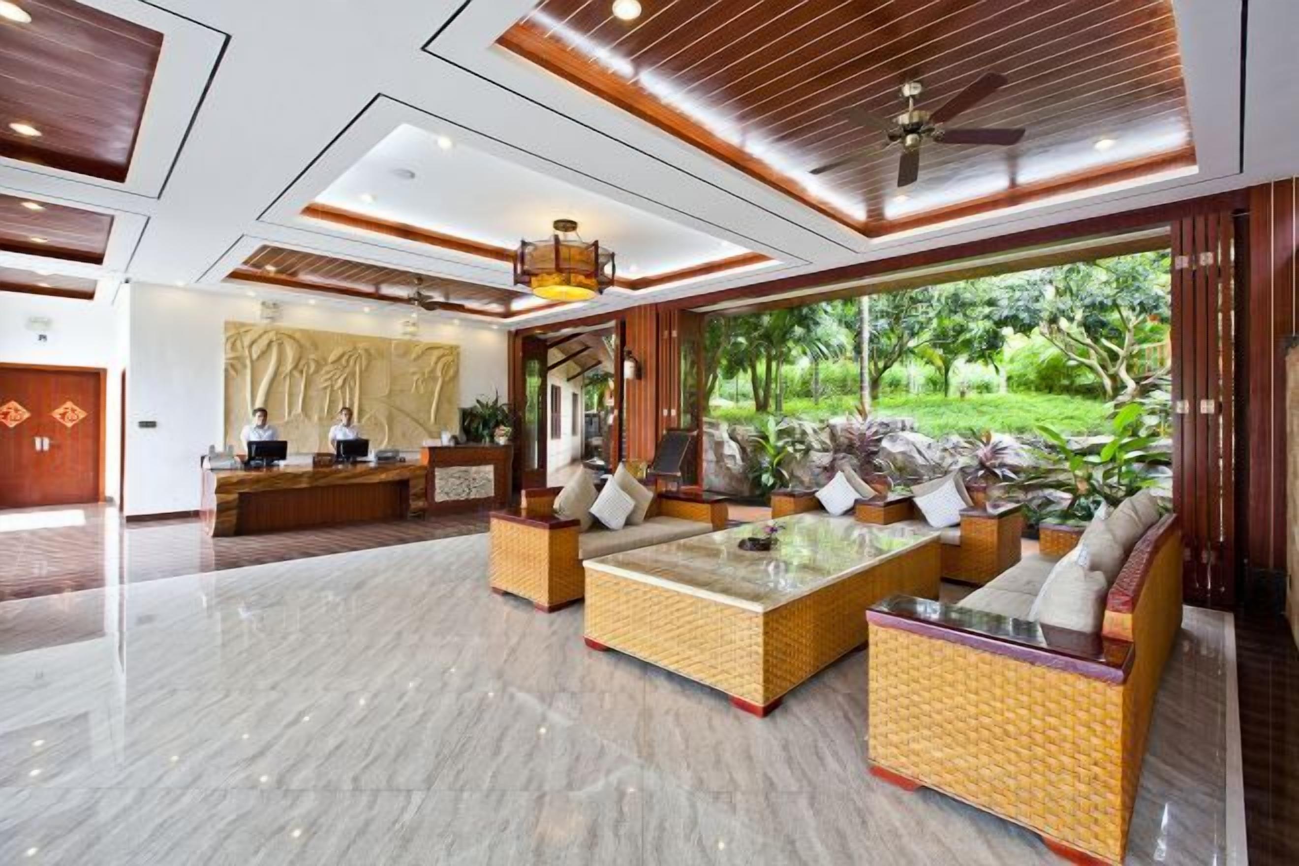 Um hall espaçoso com balcão de recepção, área de estar confortável e vista para um jardim exuberante.