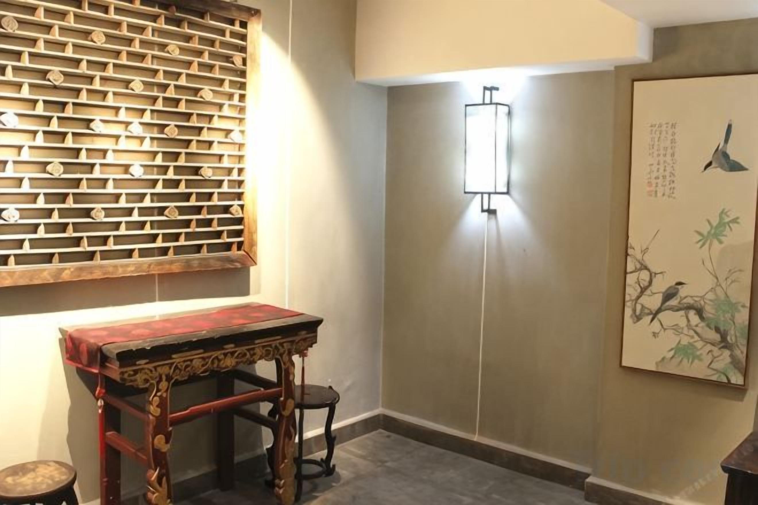 Quarto com parede de madeira tradicional, uma mesa e uma obra de arte emoldurada.