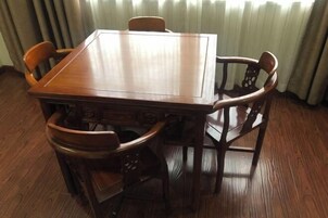 Uma mesa de jantar retangular de madeira com seis cadeiras.