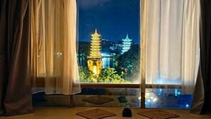 Janela com vista para um pagode à noite.