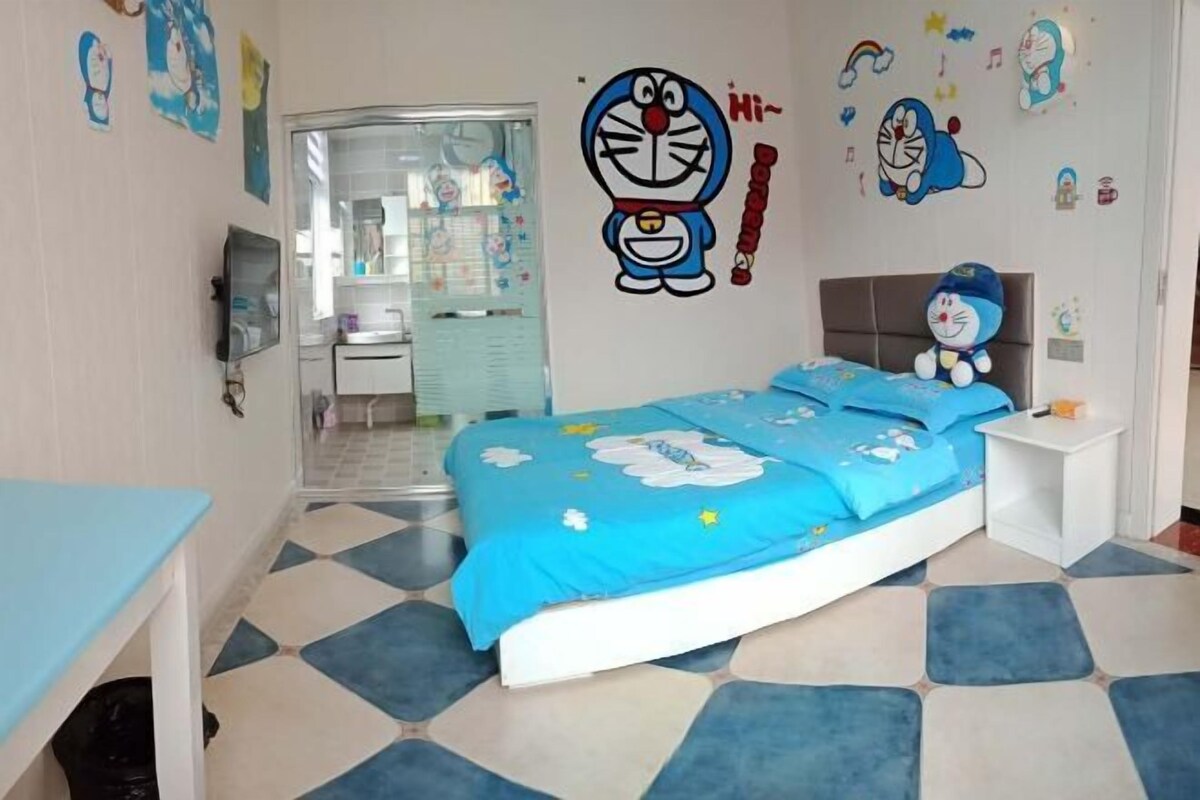 Quarto com cama, escrivaninha, espelho e porta para um banheiro.
