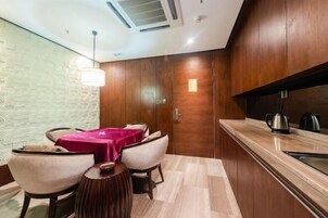 Uma cozinha moderna com armários de madeira, bancada de mármore e uma área de jantar com mesa e cadeiras.