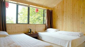 Quarto com duas camas, janela com cortinas e parede de madeira.
