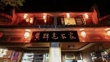 Um edifício tradicional com uma placa sobre a entrada, várias janelas e fachada de tijolos.