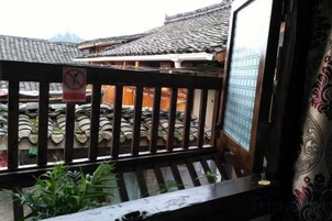 Um edifício japonês tradicional com varanda de madeira e telhados cobertos de telhas.