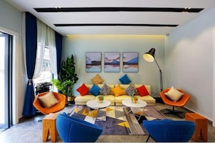 Uma sala de estar moderna com um sofá, duas poltronas, uma mesa de centro e um abajur.
