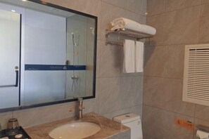 Uma casa de banho moderna com um espelho grande, uma pia, um chuveiro e um porta-toalhas.