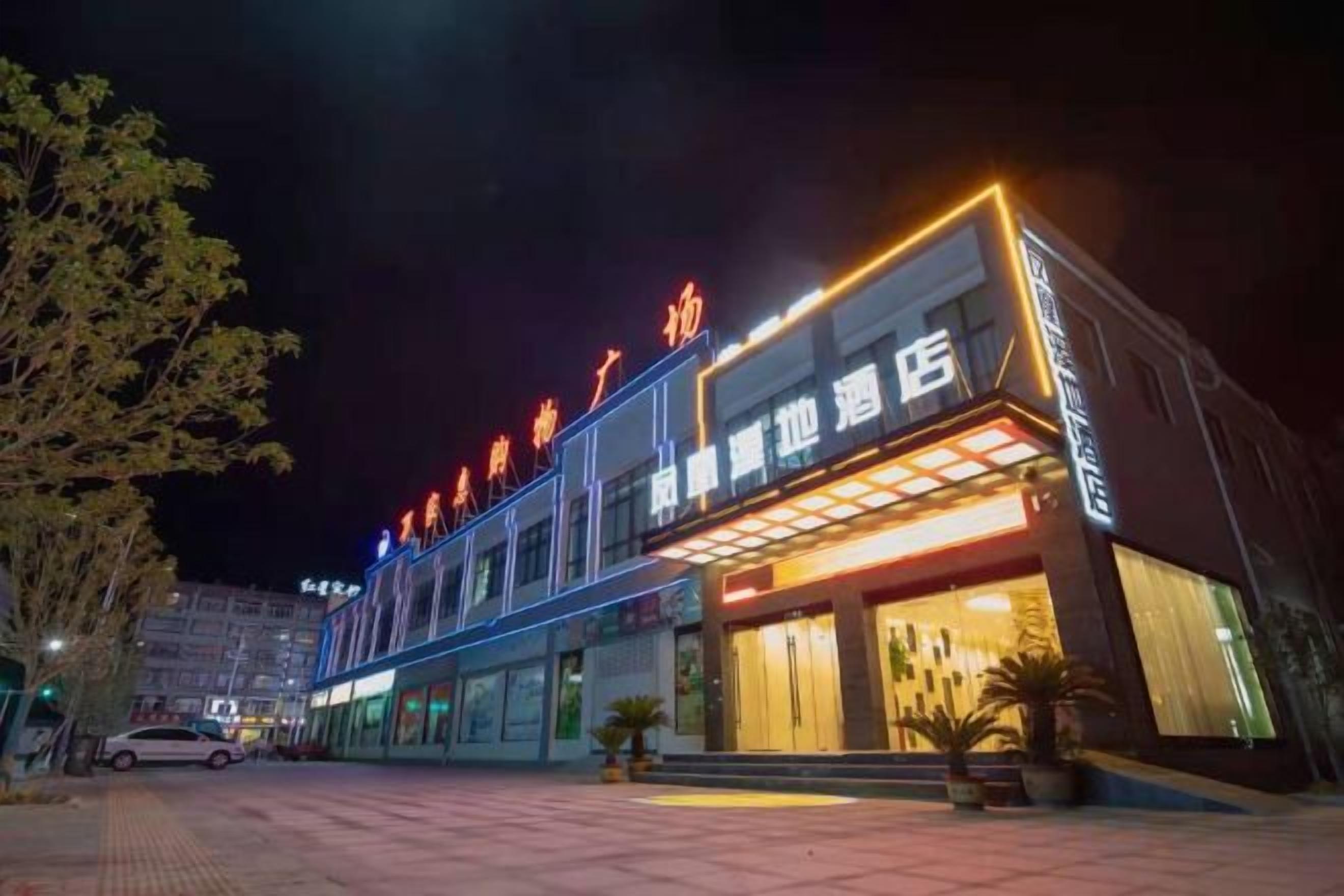 Um hotel com fachada moderna, grandes janelas e entrada bem iluminada.