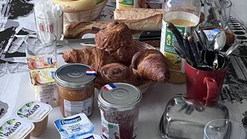 Uma mesa com diversos alimentos, incluindo pão, frutas e acompanhamentos.