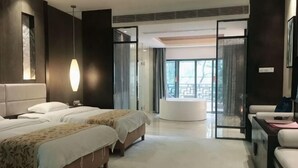 Quarto de hotel moderno com cama grande, sofá, escrivaninha e varanda com vista.