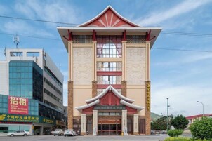 Um edifício com estilo arquitetônico tradicional, destacando uma entrada imponente com telhado decorativo e colunas.