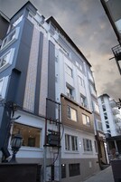 Um edifício de vários andares com espaços residenciais e comerciais, incluindo uma loja visível no andar térreo.