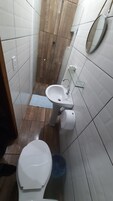 Casa de banho pequena com sanita, lavatório e espelho.
