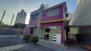 Um edifício de dois andares com fachada roxa e detalhes em amarelo.