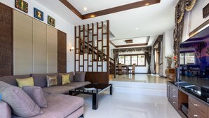 Uma sala de estar moderna com sofá, mesa de centro e painéis decorativos na parede.