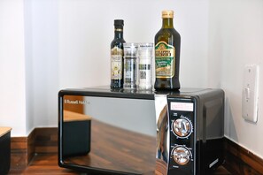 Uma torradeira Russell Hobbs com duas garrafas de azeite e um saleiro em cima.