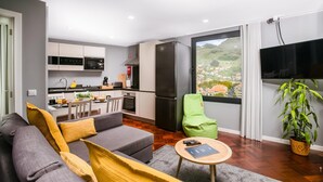 Apartamento moderno com cozinha, sala de jantar, sala de estar e uma grande janela com vista para a cidade.