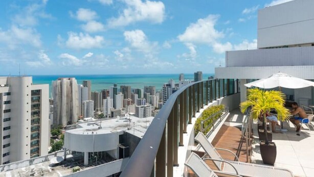 Terraço no telhado com vista para o horizonte da cidade e o oceano.