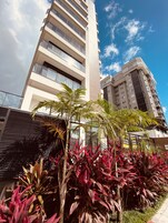 Um edifício moderno com vários varandas e um céu azul límpido.