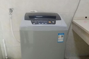 Máquina de lavar compacta e moderna, com painel de controle digital, etiqueta com código QR e cabo de energia.