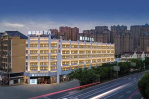 Hotel de vários andares com um pátio central, rodeado por outros edifícios.