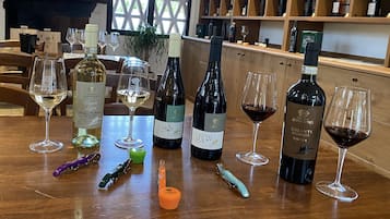 Disposição para degustação de vinhos, com diversas garrafas e copos sobre uma mesa de madeira.