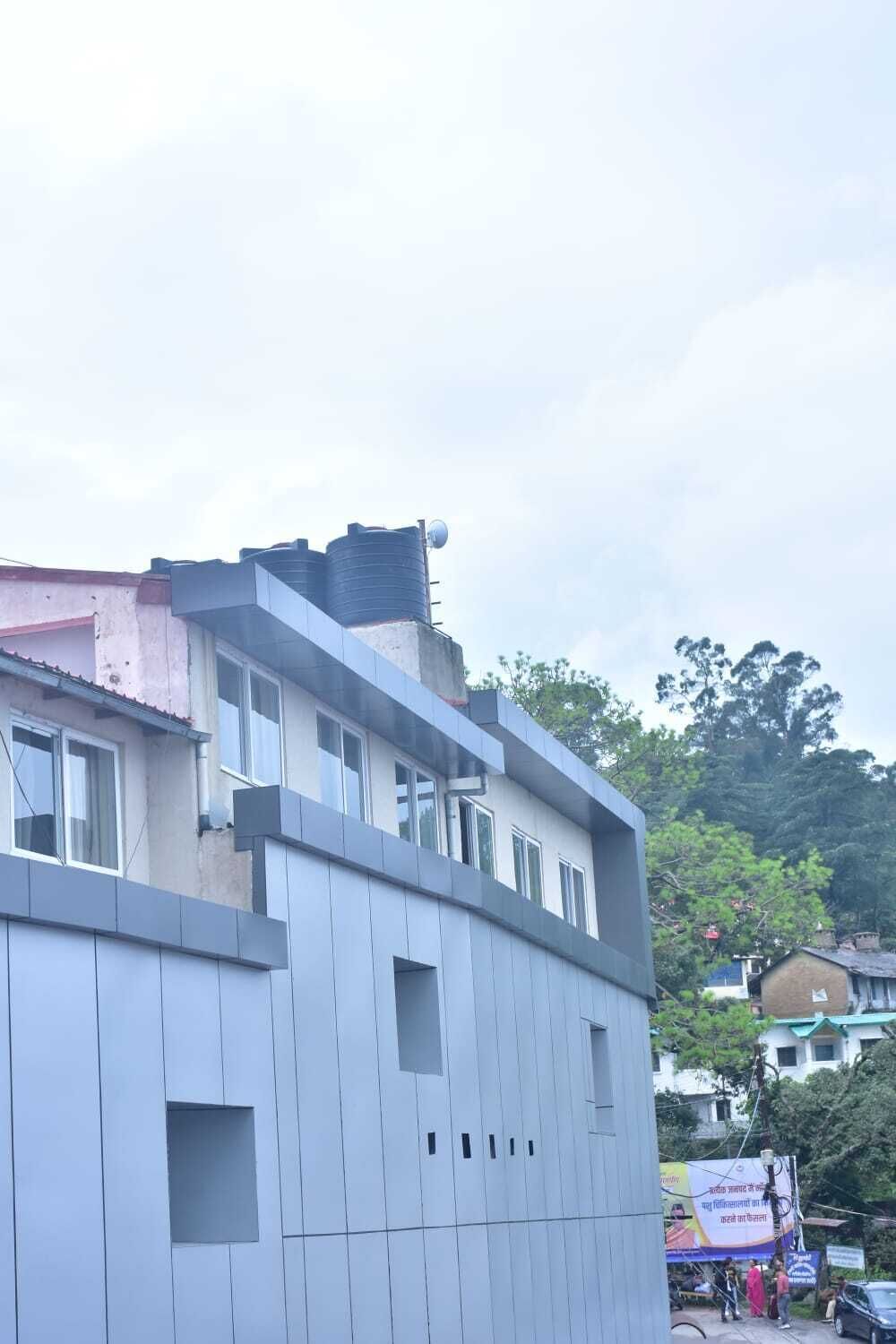 Um edifício de vários andares com telhado plano e antena parabólica. Várias janelas são visíveis na fachada, e uma pequena janela quadrada está visível no nível inferior.