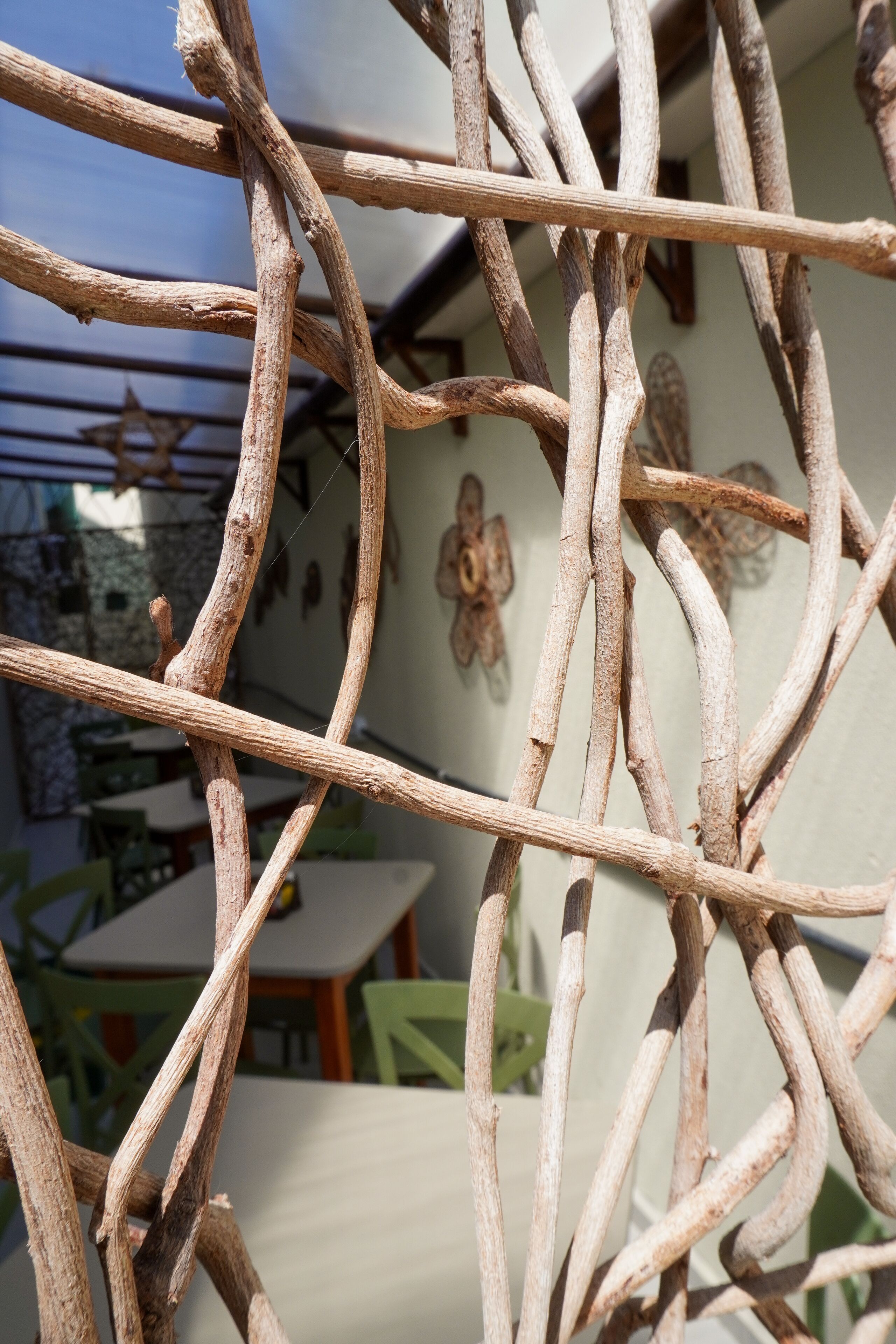 Uma área de estar ao ar livre rústica com mobiliário de madeira e uma parede decorativa.