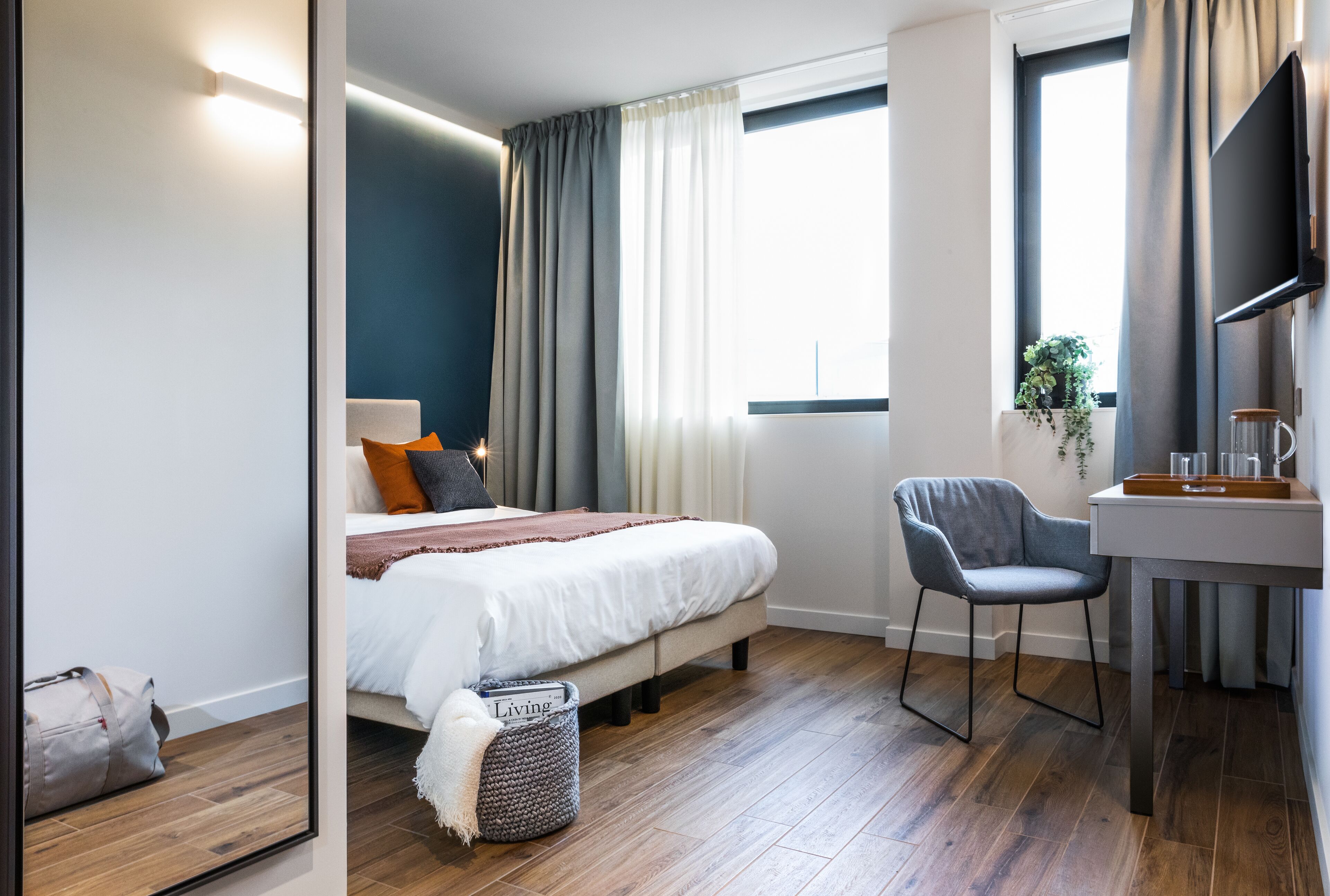 Quarto de hotel moderno com cama, escrivaninha e cadeira.