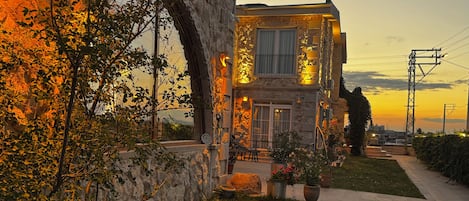 Um edifício de pedra com jardim e área de estar ao ar livre.