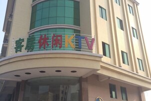 Hotel com placa que diz '客房休闲KTV', indicando um quarto com área de TV.