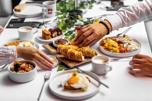 Um cenário de café da manhã com diversos pratos, incluindo ovos, doces e um croissant.