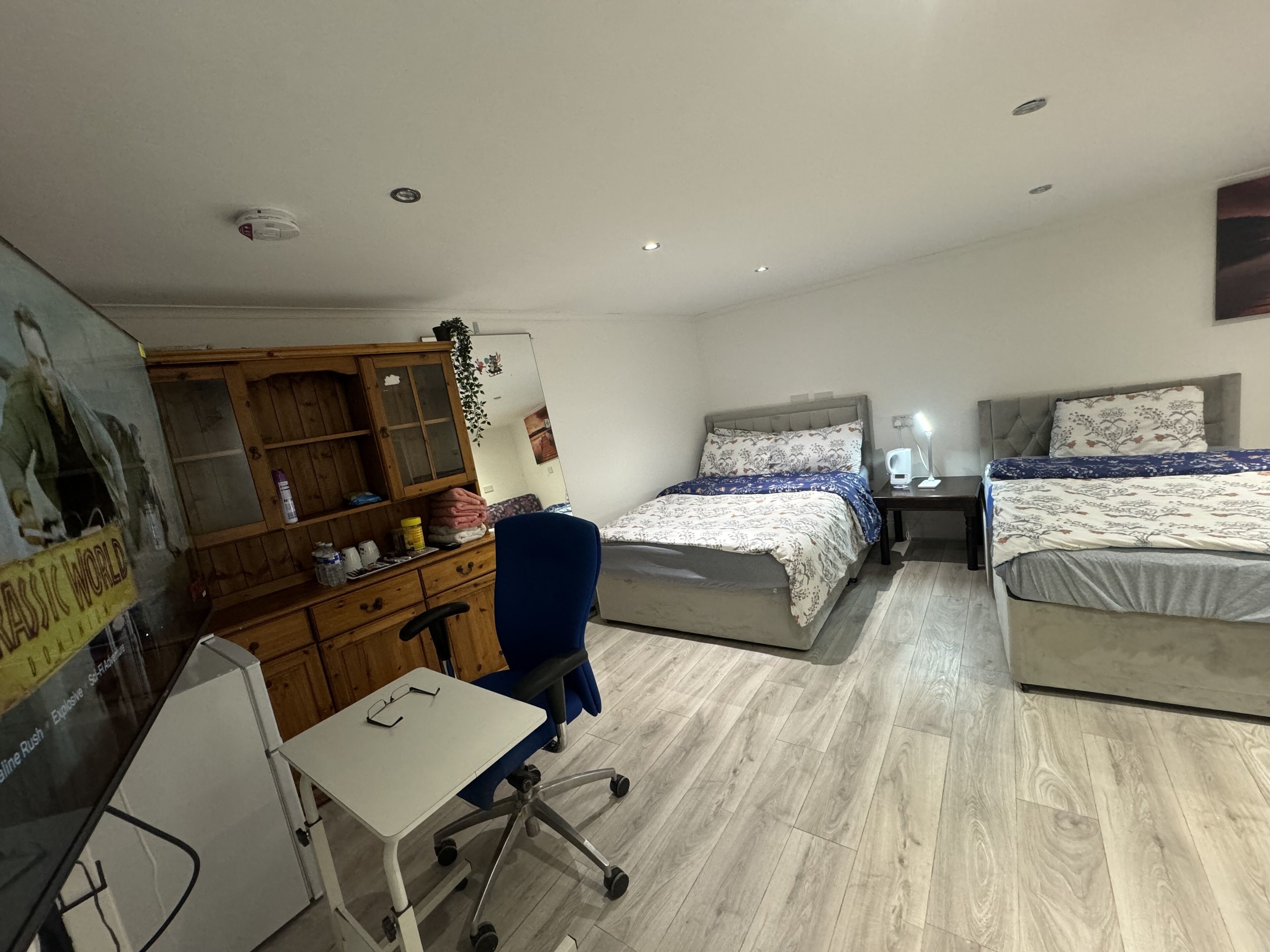 Quarto com duas camas, uma escrivaninha e um guarda-roupa.