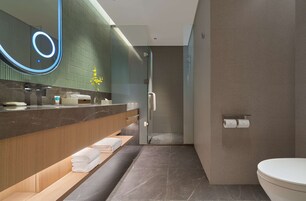 Uma casa de banho moderna com lavatório de mármore, cabine de chuveiro em vidro e sanita.