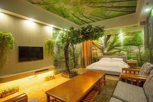 Quarto moderno com cama, sofá e mesa de jantar.