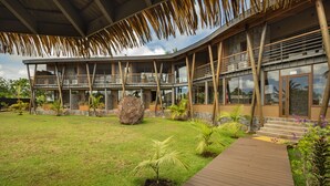 Um edifício moderno com telhado curvo, várias varandas e um deck de madeira.